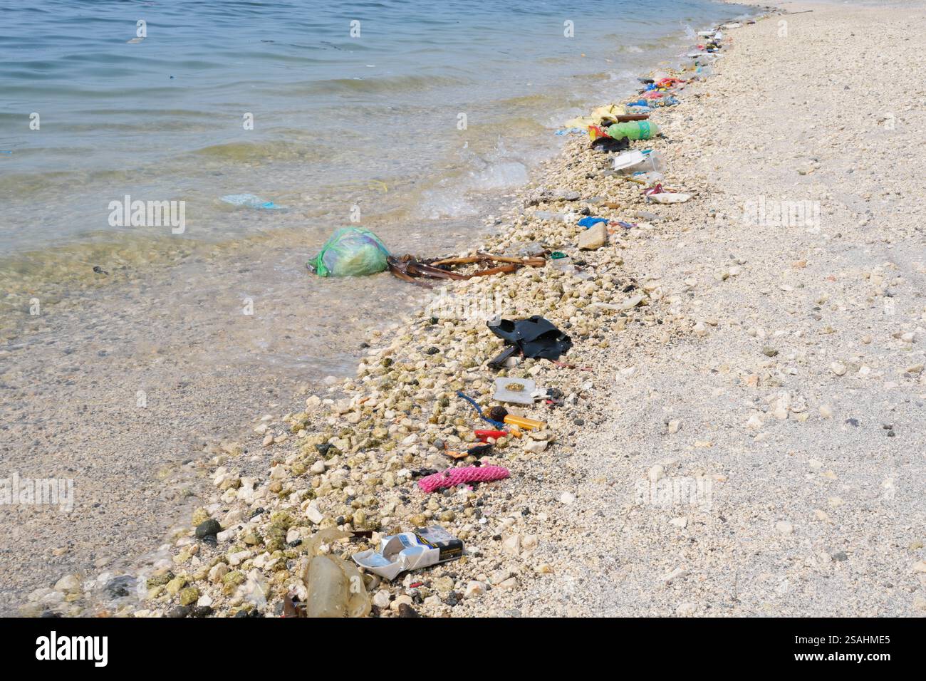 Garbage trash rubbish waste being washed to the shoreline by sea waves ...