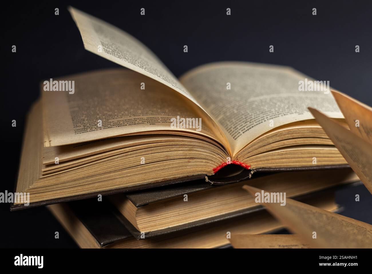 opened book, lying on the bookshelf in library Stock Photo - Alamy