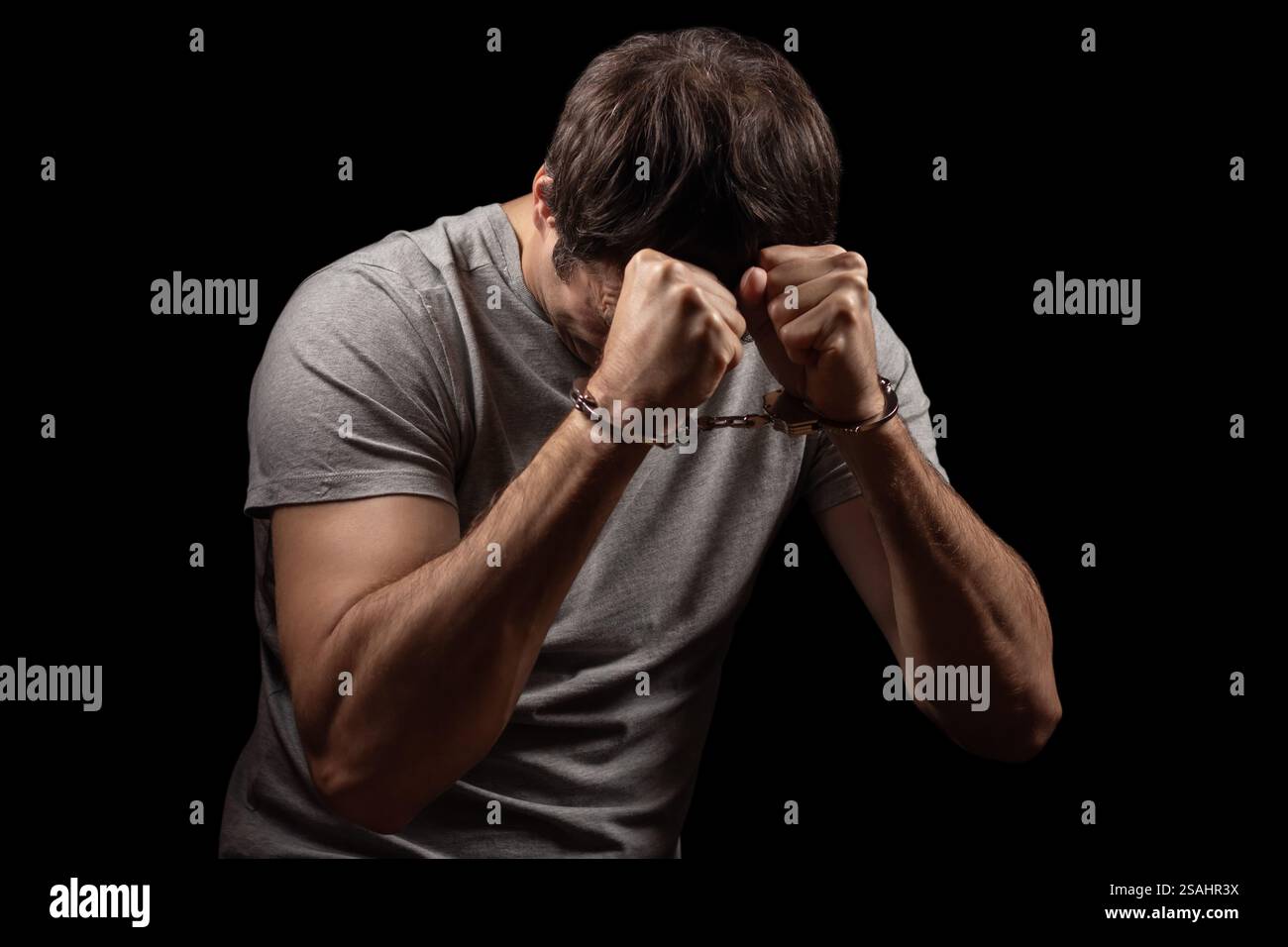 Handcuffed man covering his face with his hands. Arrested and ...