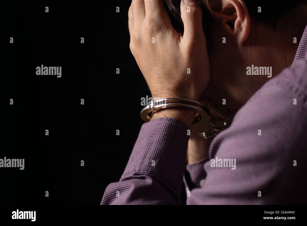 Businessman in handcuffs arrested for financial fraud, sitting in ...