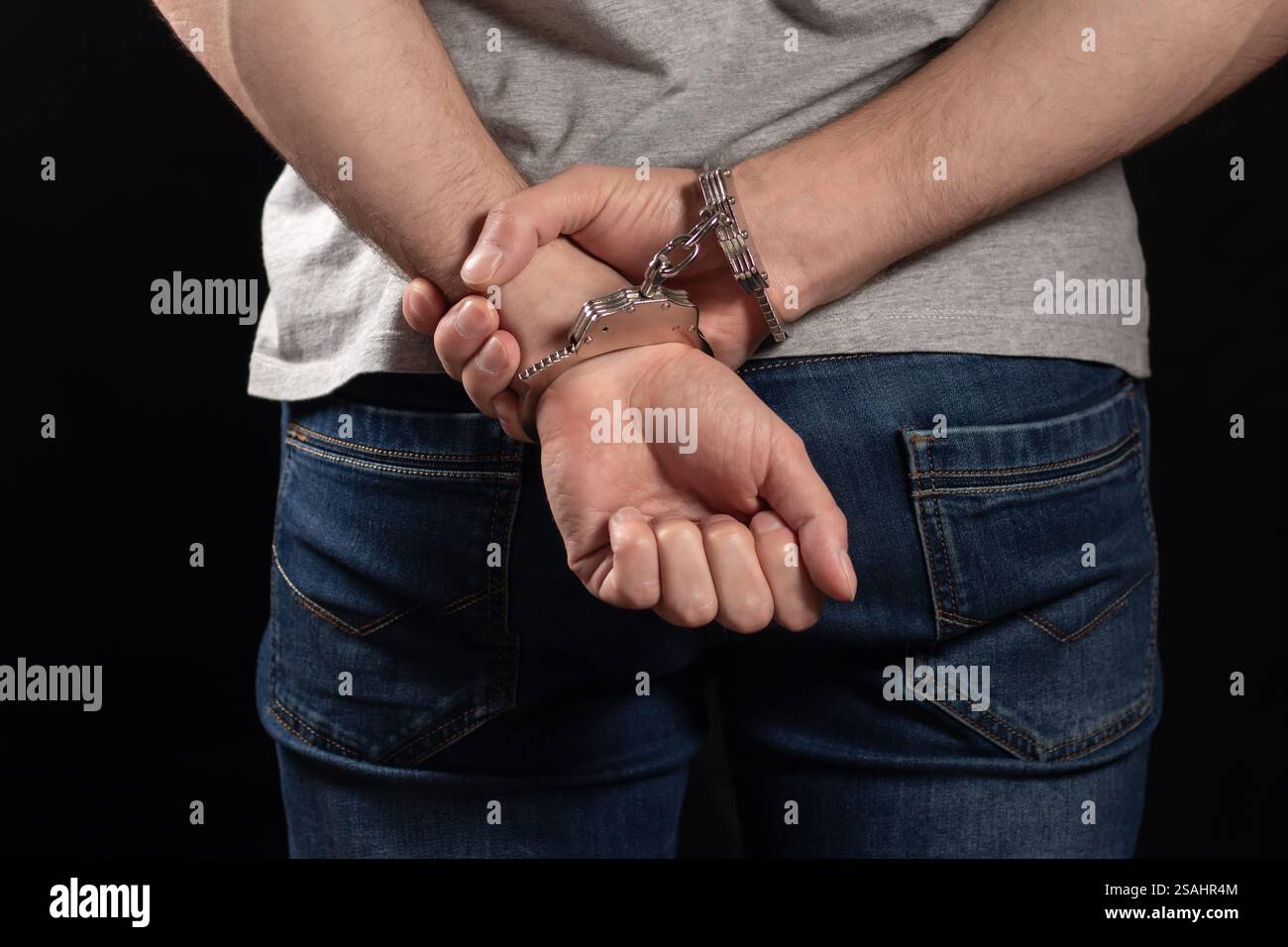 Arrested man in handcuffs with handcuffed hands behind back in prison ...