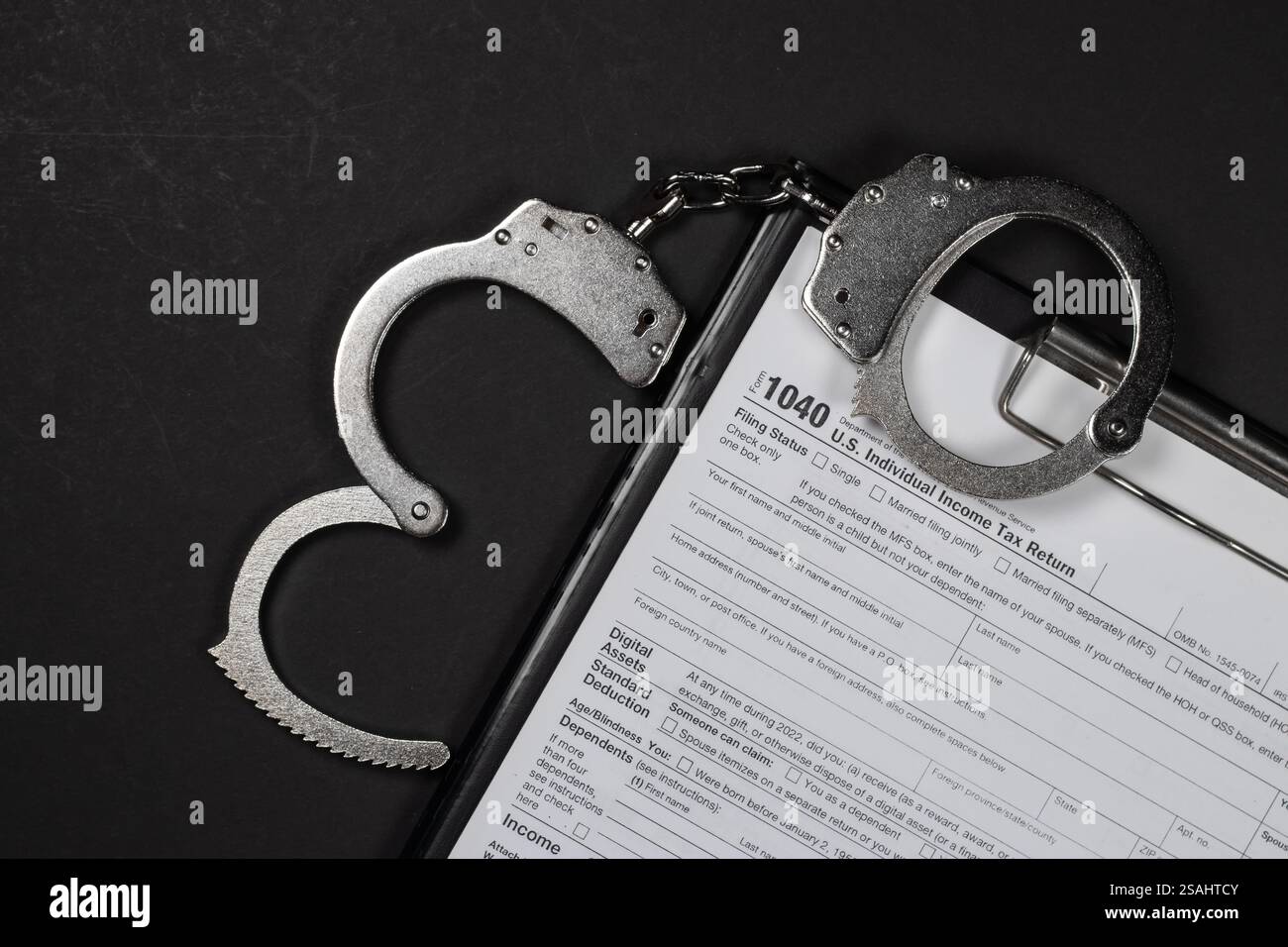 Income tax return documents and handcuffs. Tax evasion, crime and fraud ...