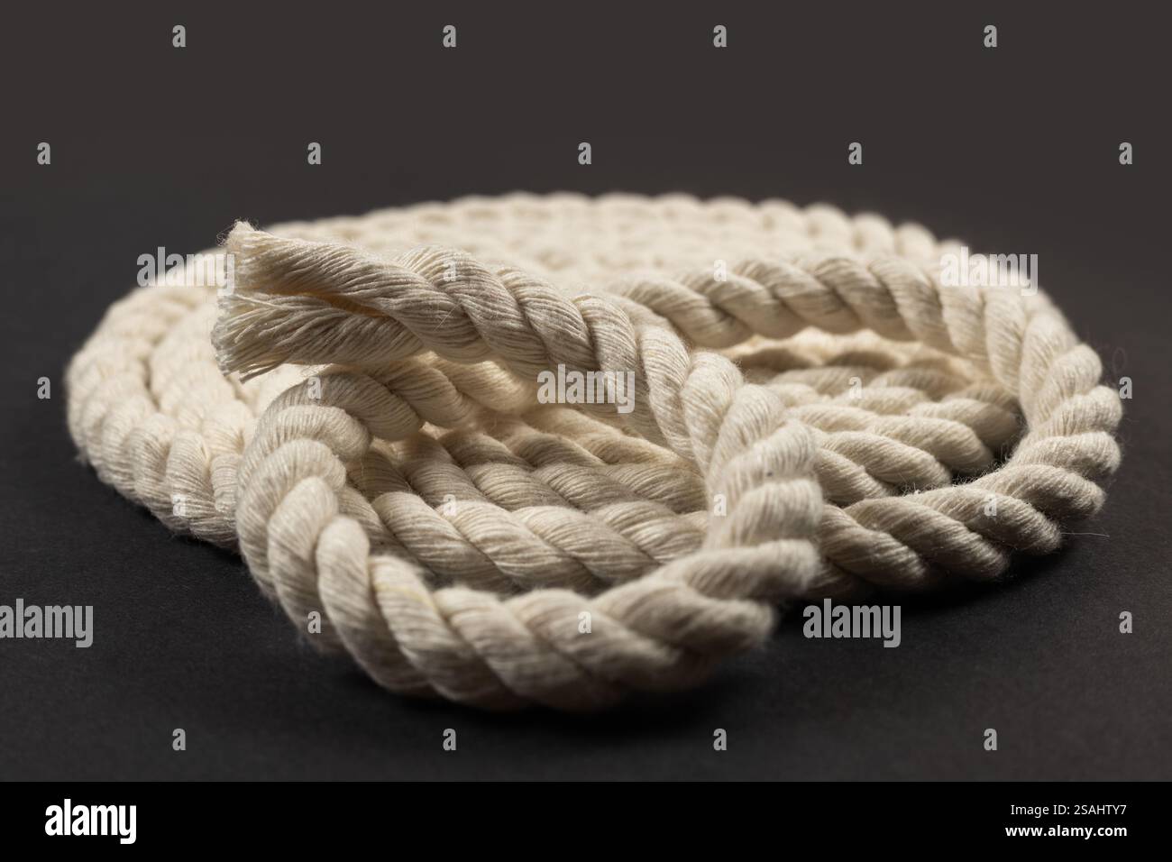 Coiled rope over a dark background Stock Photo - Alamy