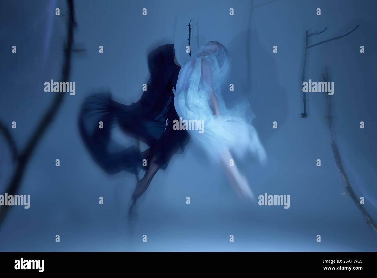 Darkness meets light. Two female ballet dancers, ghost like figures ...