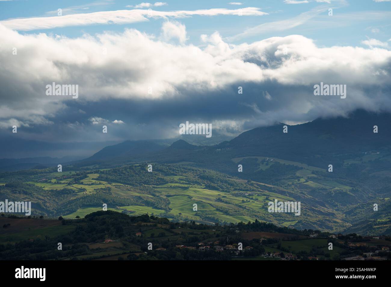 Landscape with Green fields and distant Mountains under a cloudy sky in ...