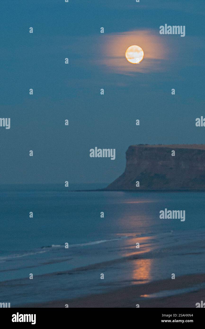 full moon rising over hunt cliff and the north sea Stock Photo - Alamy