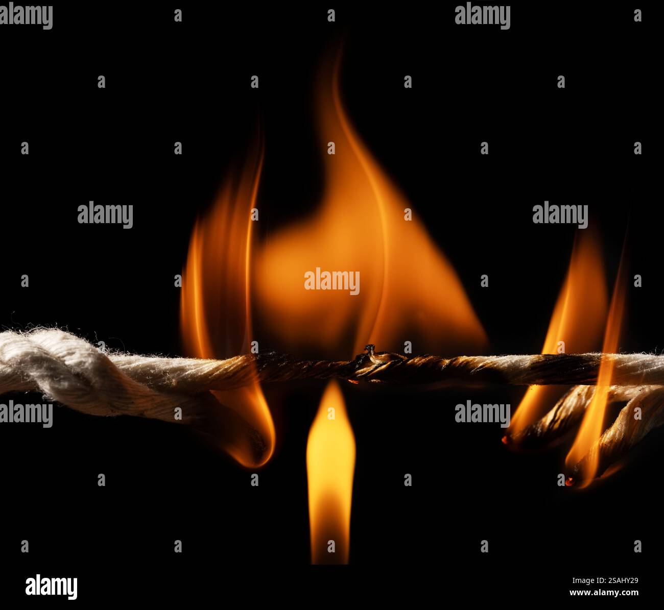 Burning frayed rope at breaking point on black background Stock Photo ...