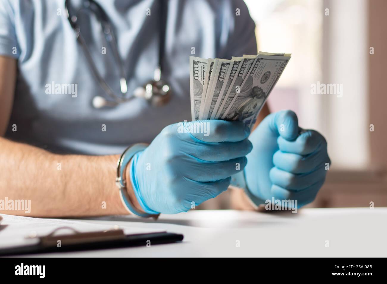 A doctor with dollar bank notes and handcuffs. concept of medical ...