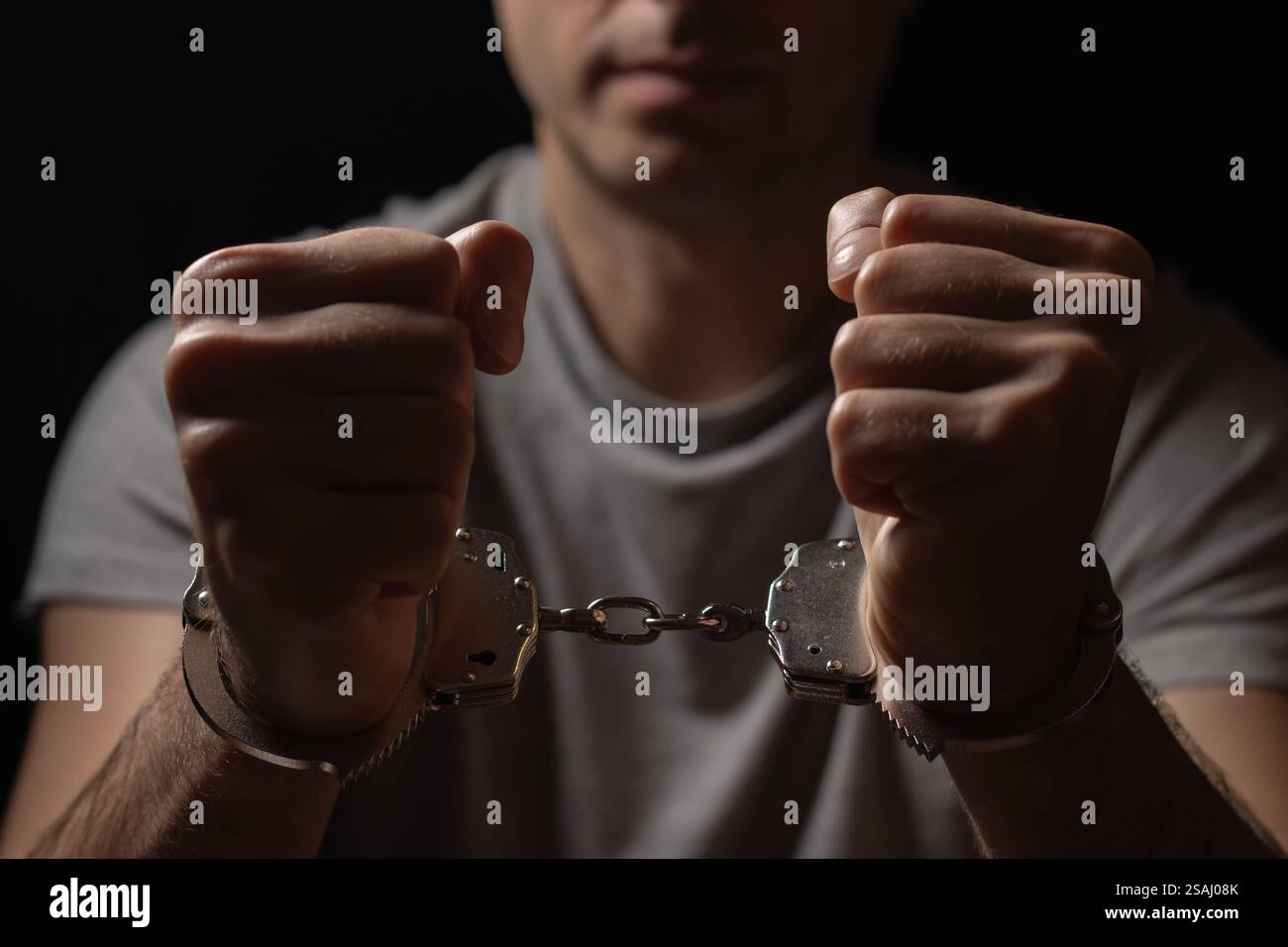 The arrested criminal handcuffed. Hands with handcuffs in the front ...