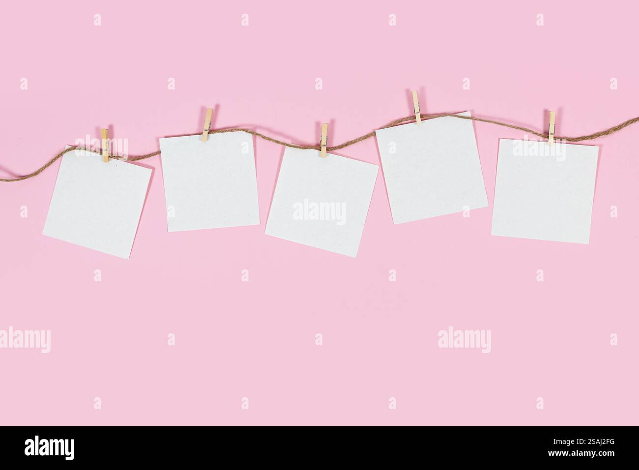 White paper cards on clothes-pegs on pink background Stock Photo - Alamy