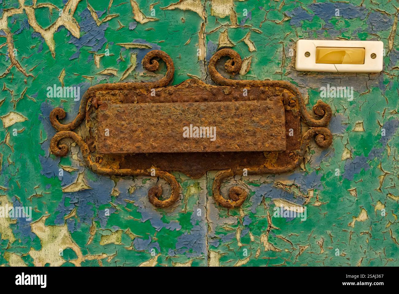 Close-up, old shabby dilapidated front door with antiquated rusty mail ...