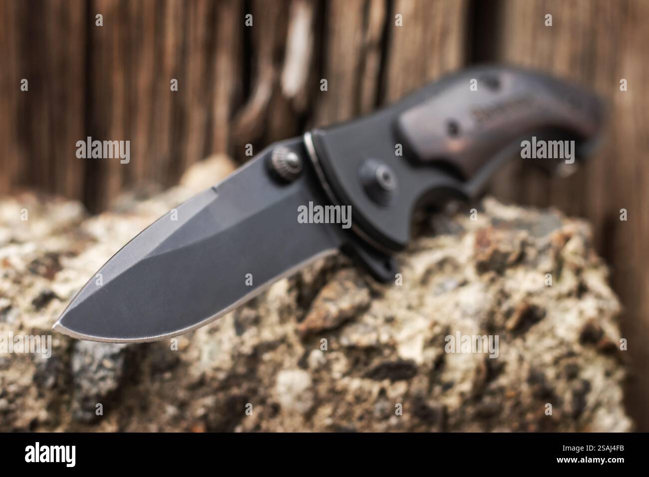 Tactical folding knife for survival on stone background Stock Photo - Alamy