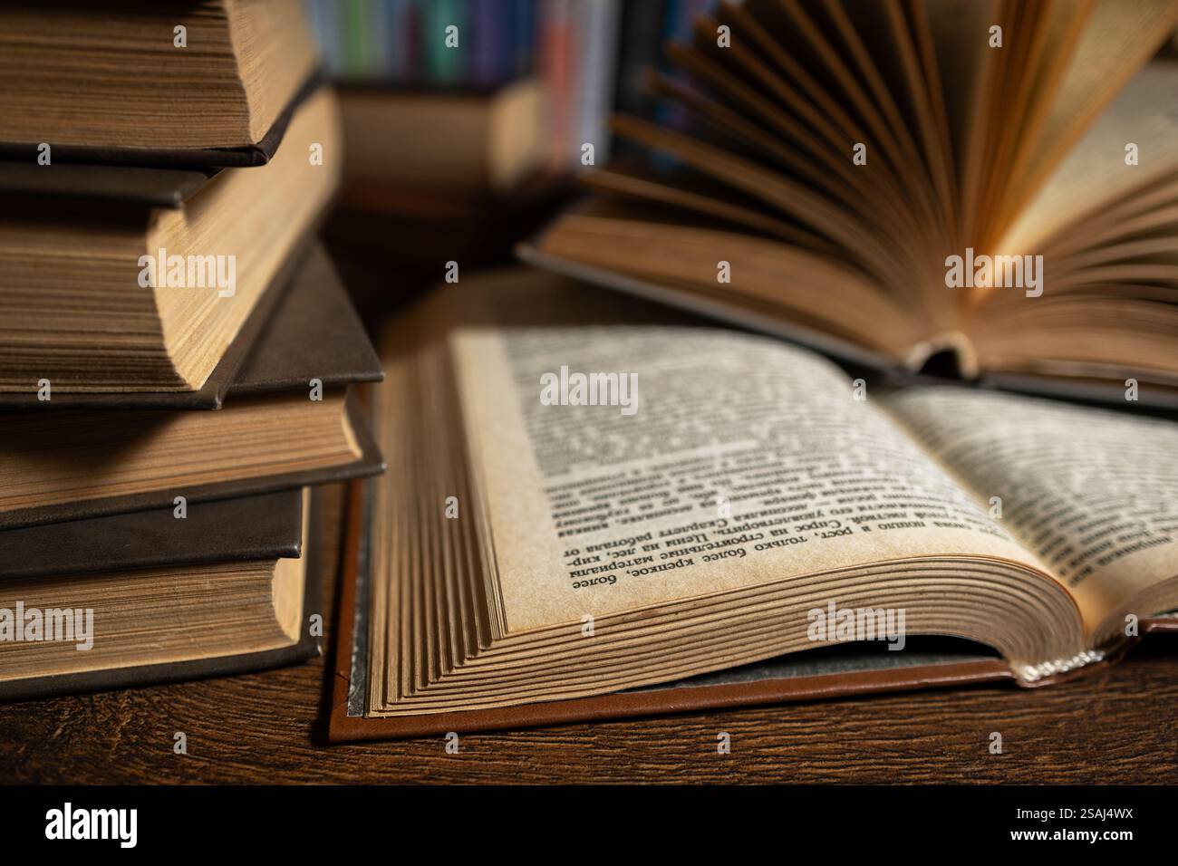 opened book, lying on the bookshelf in library Stock Photo - Alamy