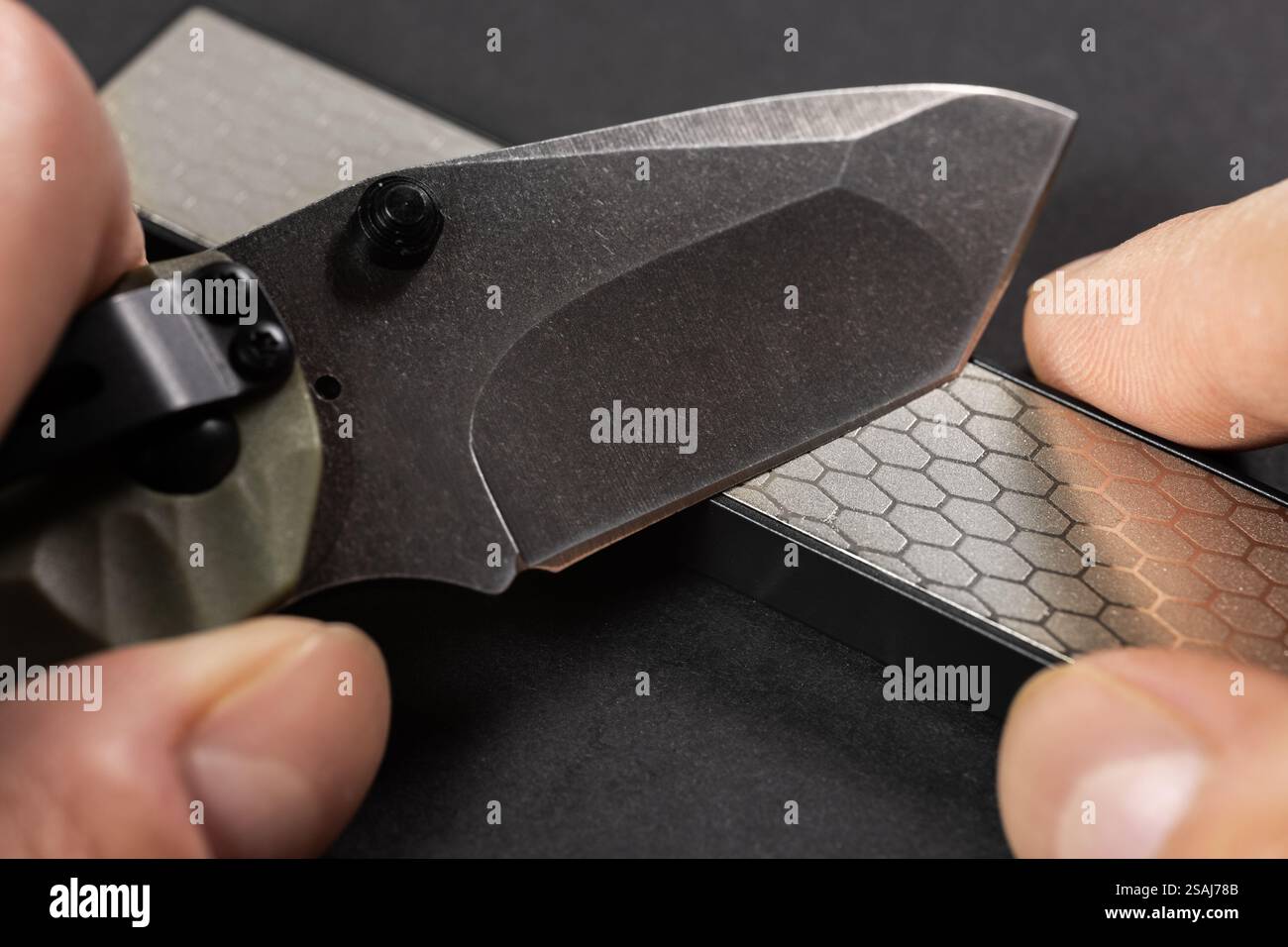 Man sharpens knife on grindstone hi-res stock photography and images ...
