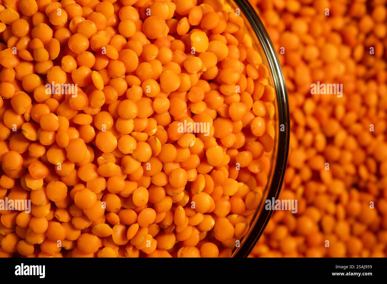 Red lentils in bowl on a lentils background Stock Photo - Alamy