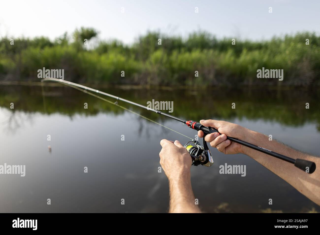 Fishing in river. A fisherman with a fishing rod on the river bank. Man ...