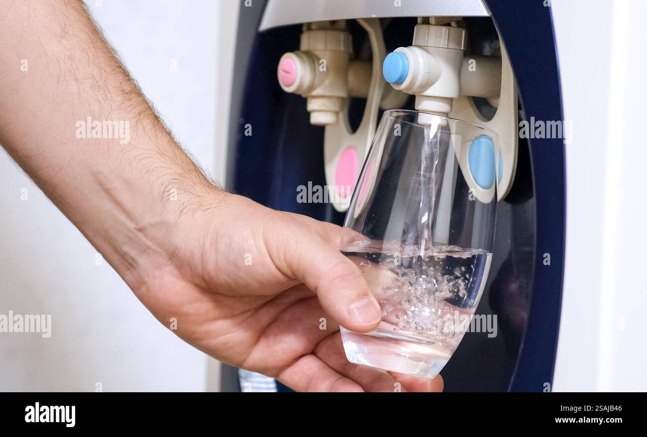 Hand filling a glass of cold water in cooler, close up Stock Photo - Alamy