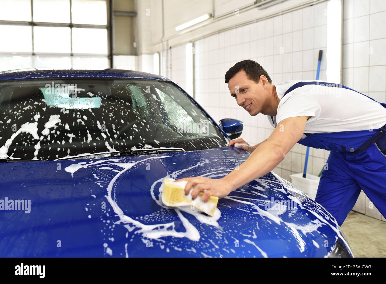 Car wash - employees of a car dealership clean a vehicle professionally ...