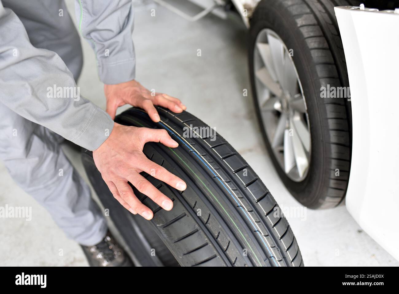 tyre change in a car repair shop - worker assembles rims on the vehicle ...