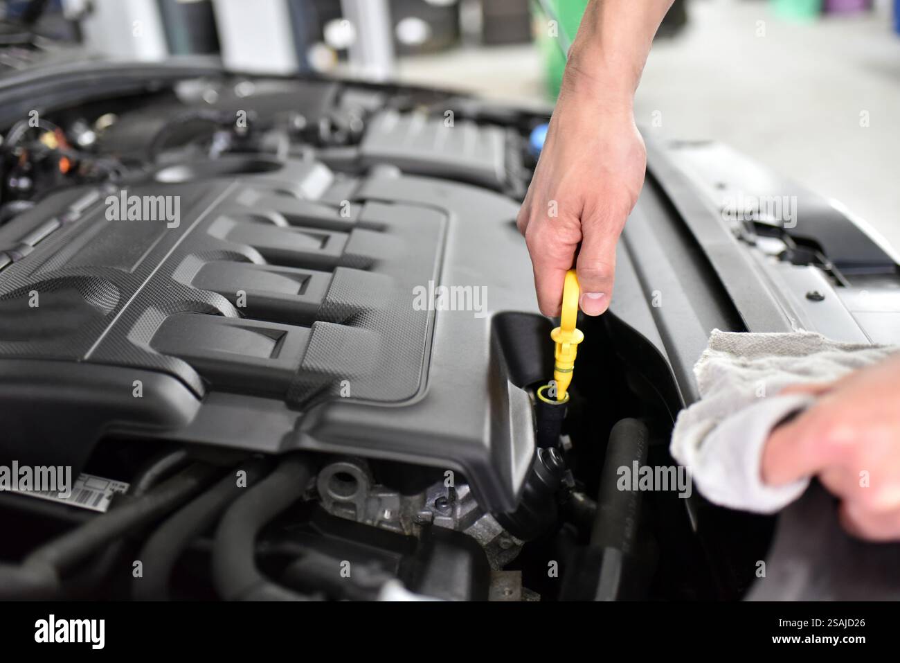 oil level control of the car engine by mechanics in a car workshop ...