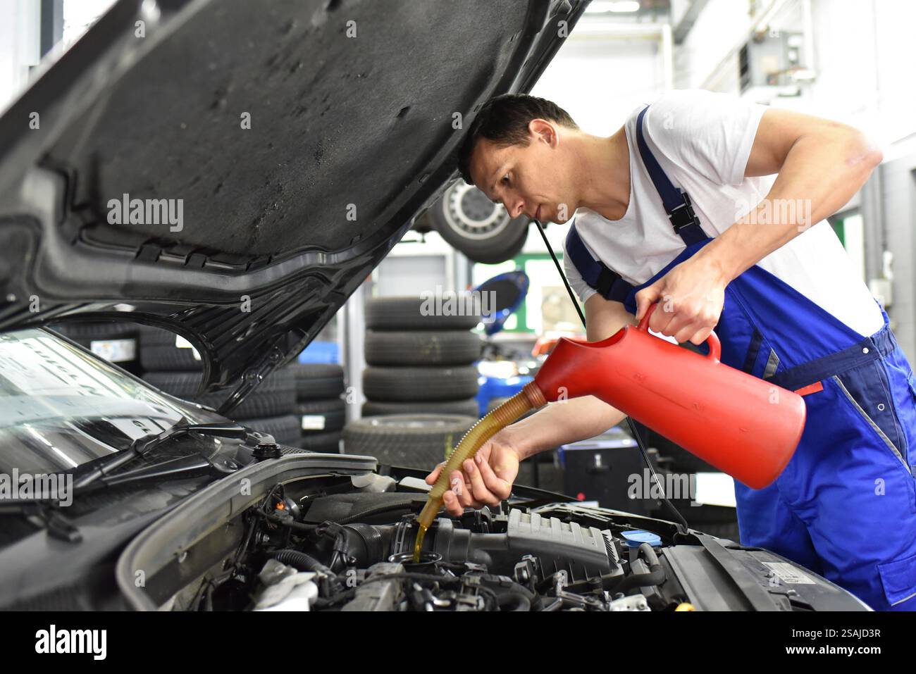 oil change from the engine of a car in a workshop by a professional ...