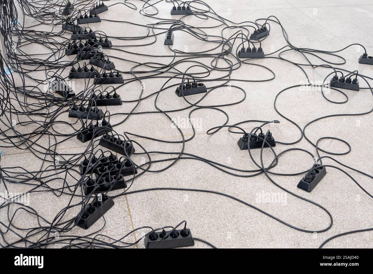 Lots of tangled wires and extension cords on the floor Stock Photo - Alamy