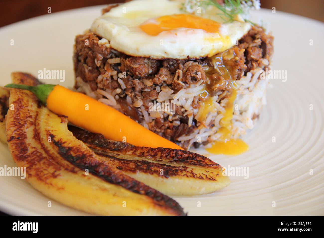 Peruvian arroz tapado topped with fried egg and served with fried ...