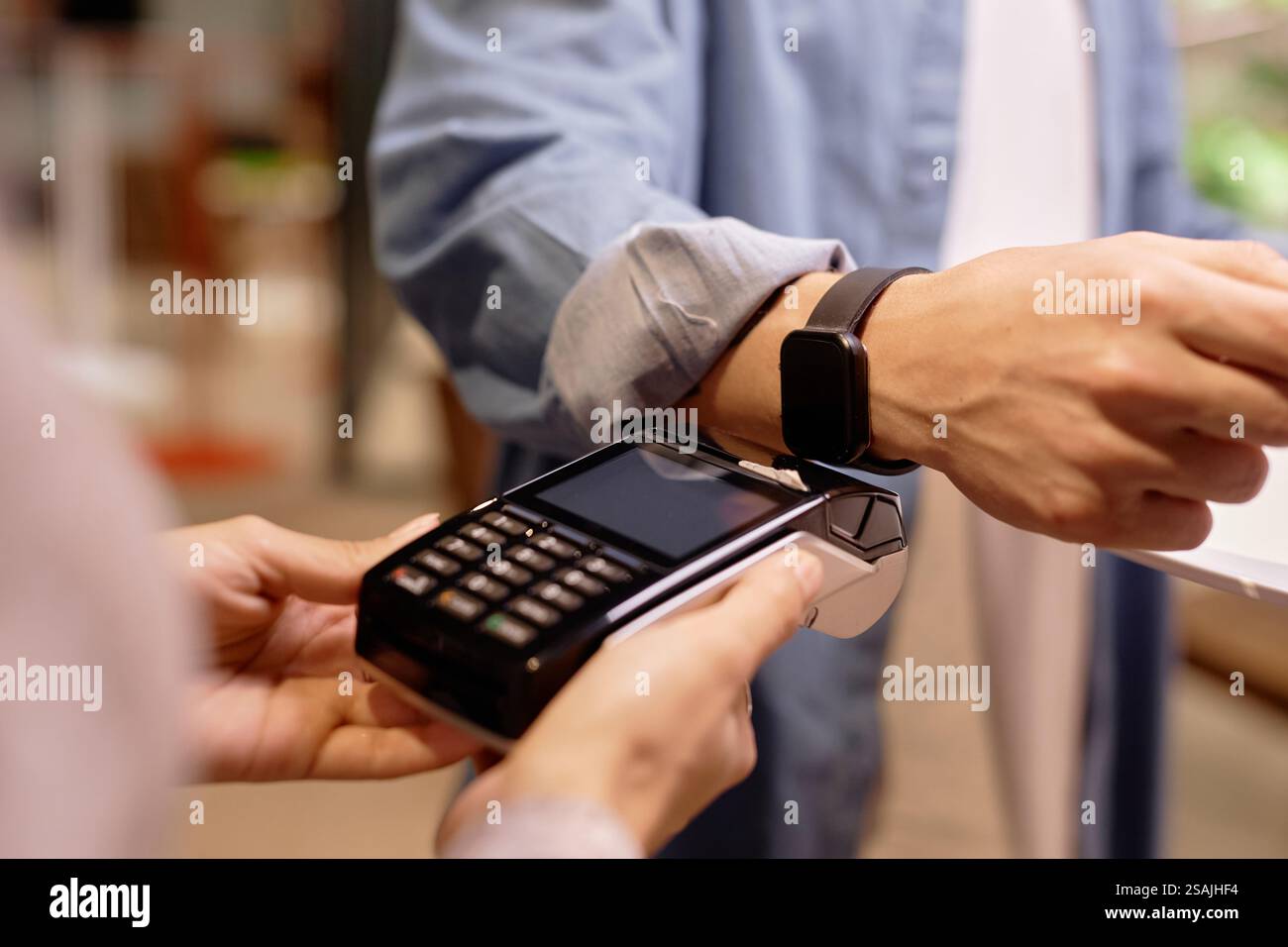 Close-up image of man's hand using smartwatch for contactless payment ...