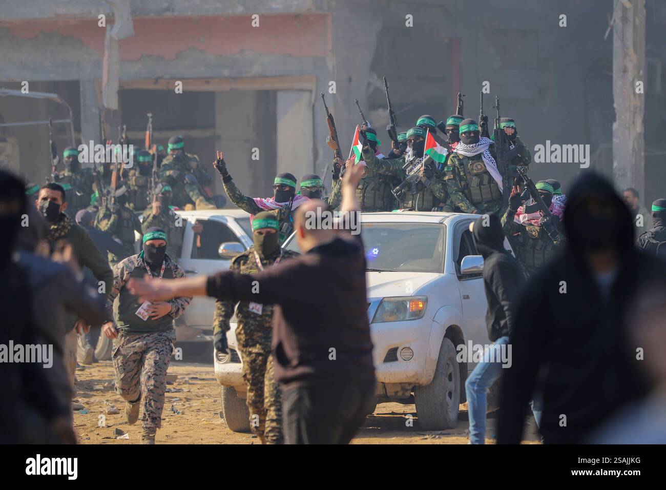 Hamas fighters are greeted as they arrive in pick-up trucks to the site ...