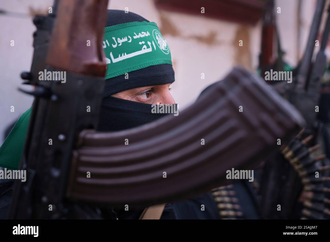 A member of Islamic Jihad fighter holds his weapon as cars carrying ...