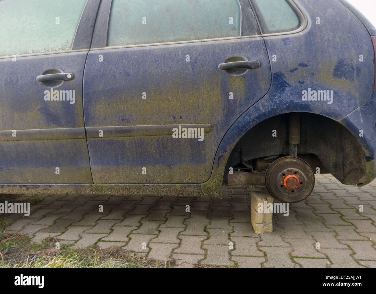 Abandoned Car Missing a Wheel on Blocks Stock Photo - Alamy