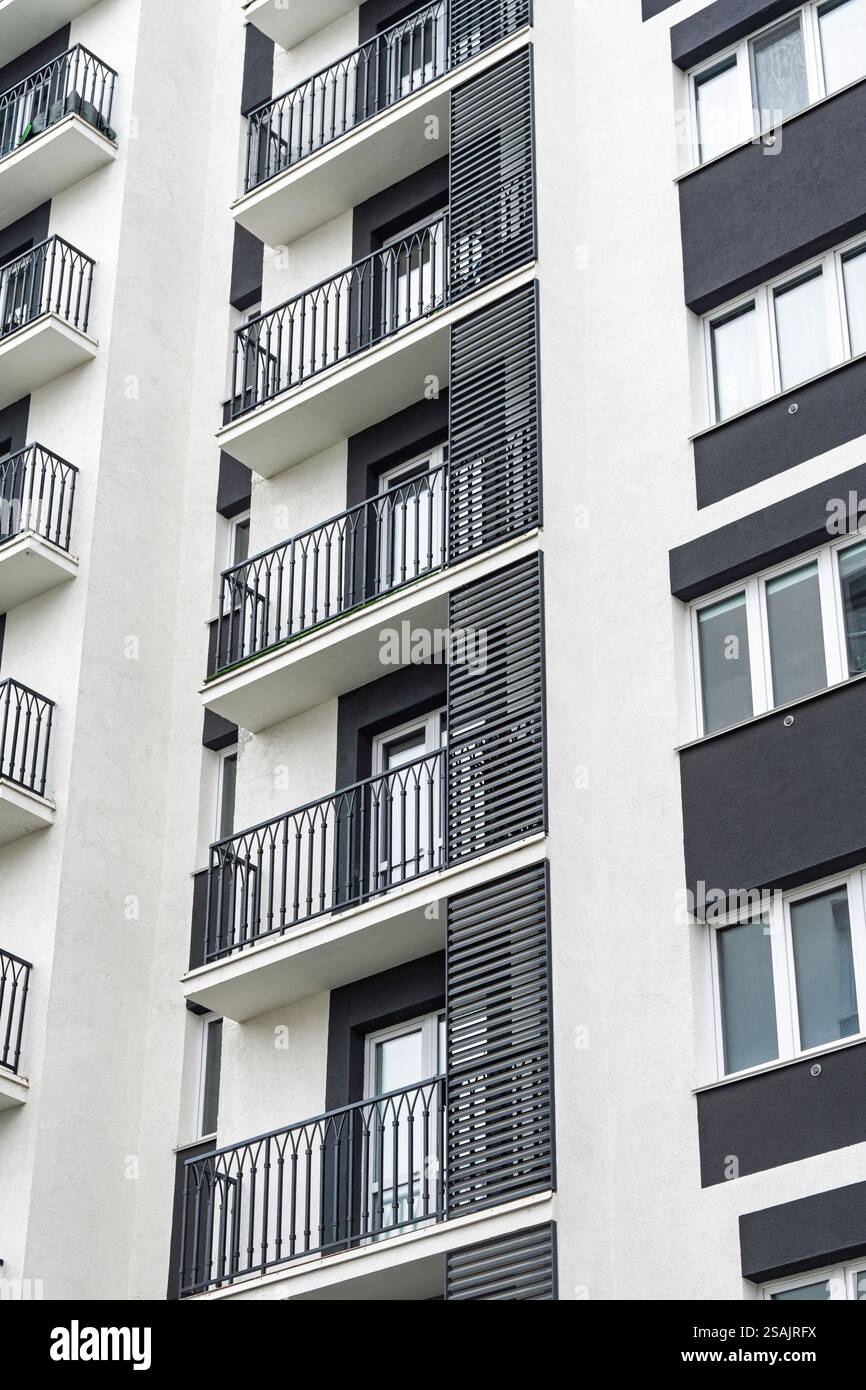 Close-up of a modern apartment building facade with black railings ...