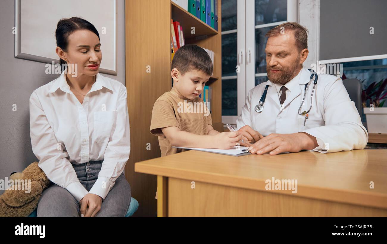 Positive service. Boy, child making notes on table while mother and ...