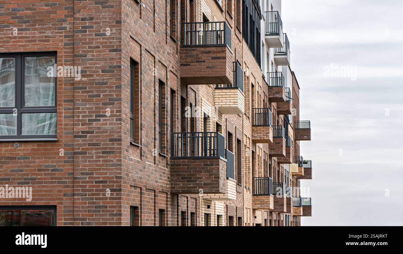 Modern brick building with multiple balconies with metal railings and ...