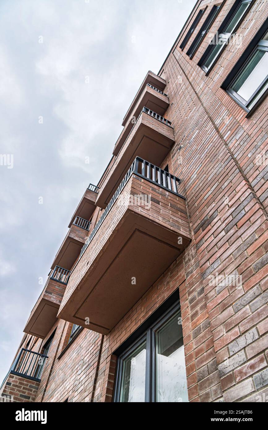 Modern brick building with multiple balconies with metal railings ...