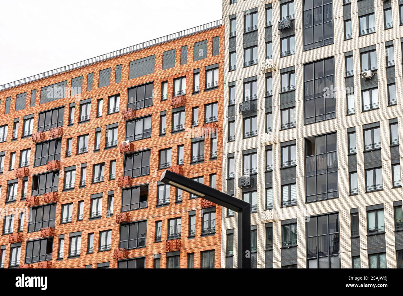 Modern multi-story buildings with beige, red brick and glass facades ...