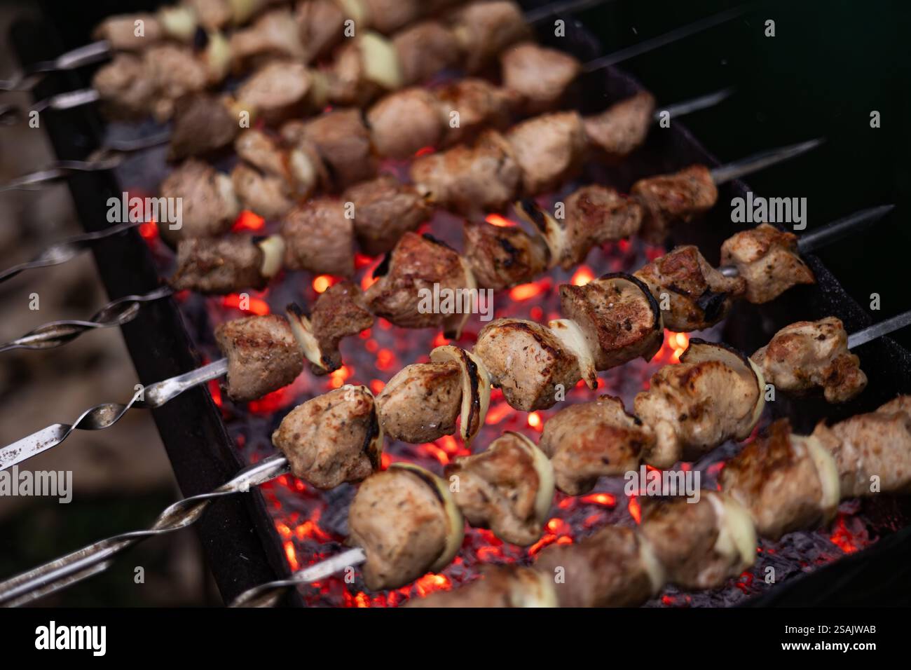 Marinated shashlik preparing on a barbecue grill over charcoal ...