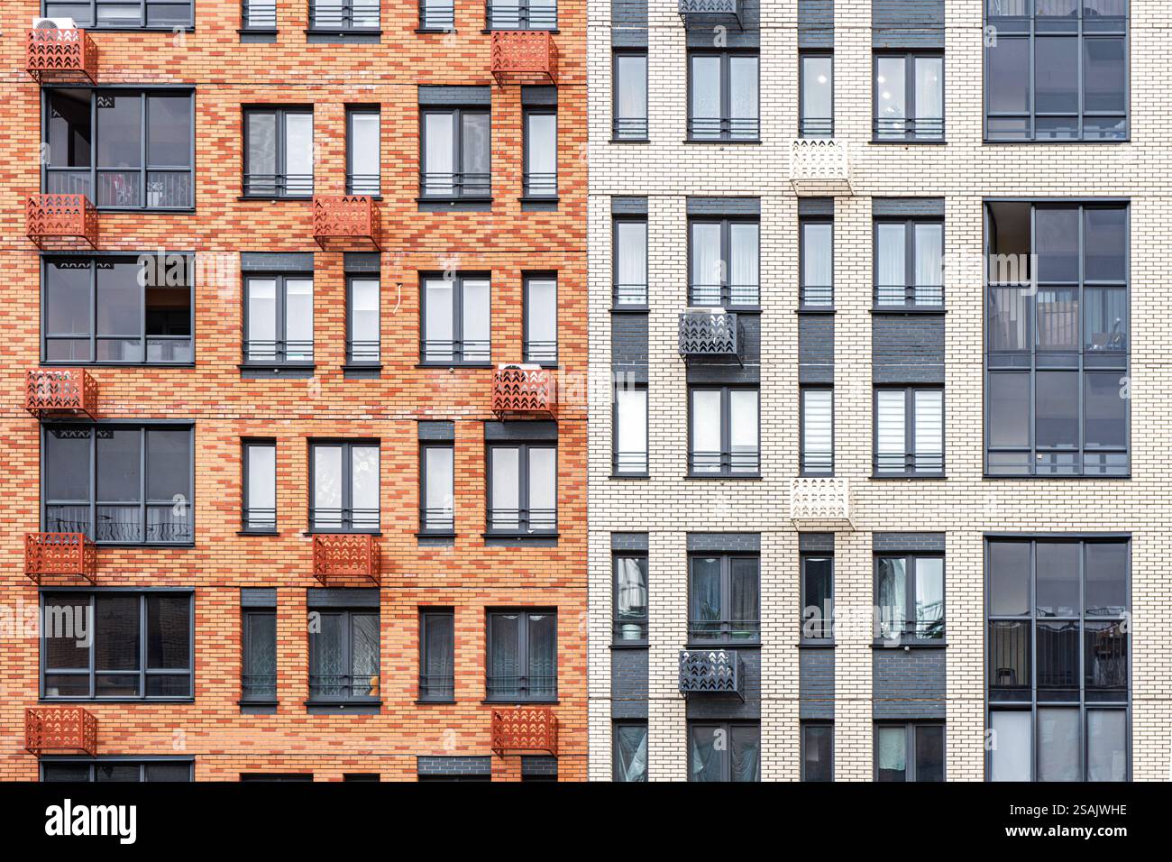 Contemporary multi-story buildings with beige, red brick and glass facades, showcasing balconies ...