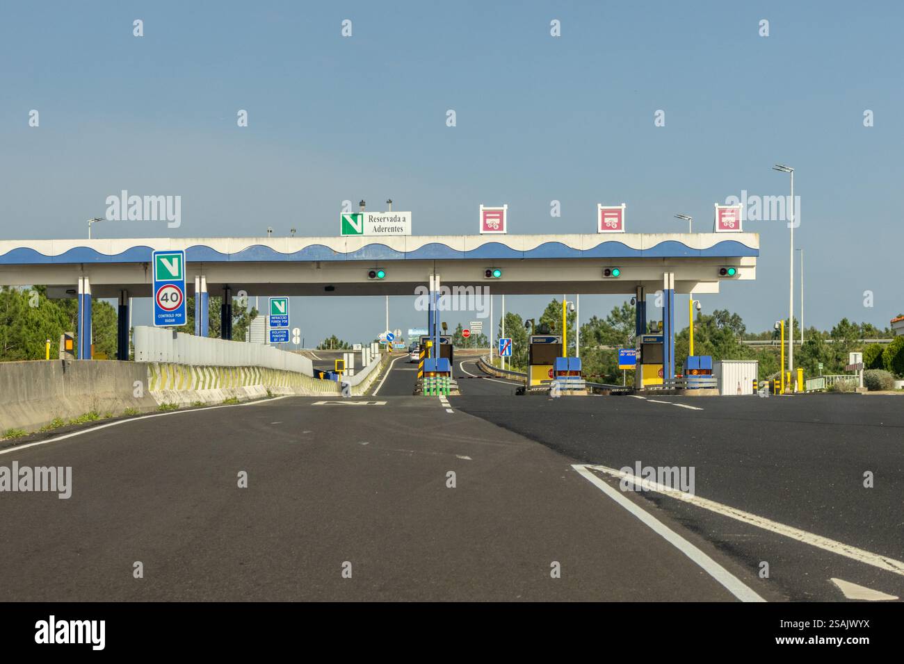 Empty highway toll booths on a sunny day with green traffic lights ...