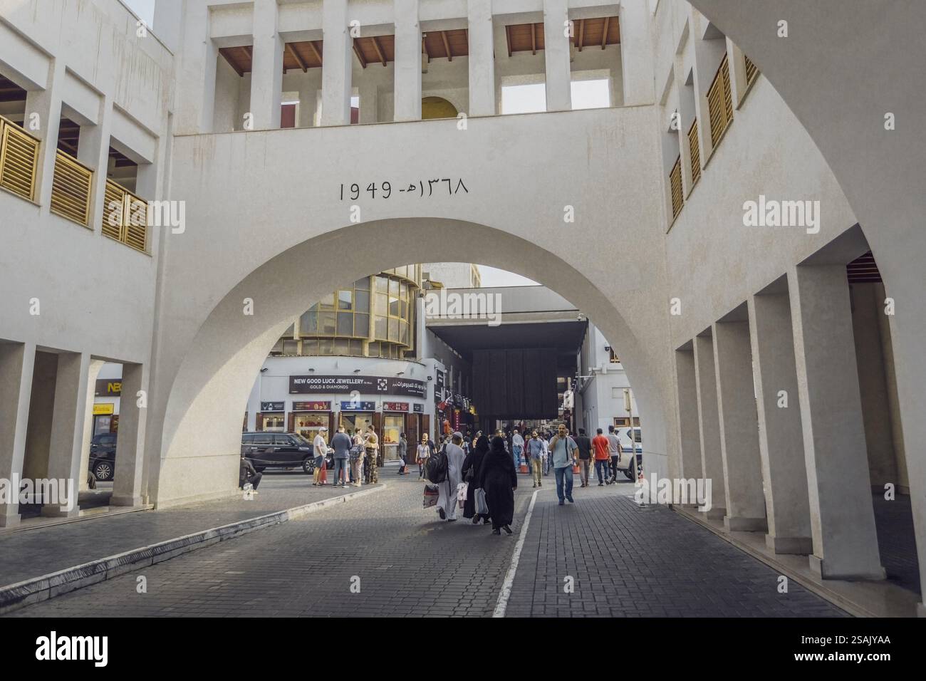 People walking through the market gate at Manama Souq traditional ...