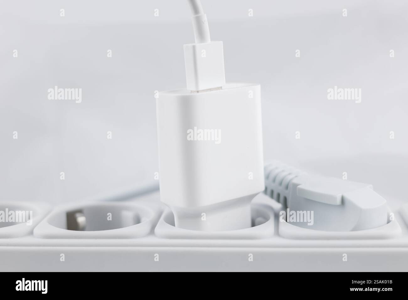 mobile phone chargers connected to electrical power strip. Various ...