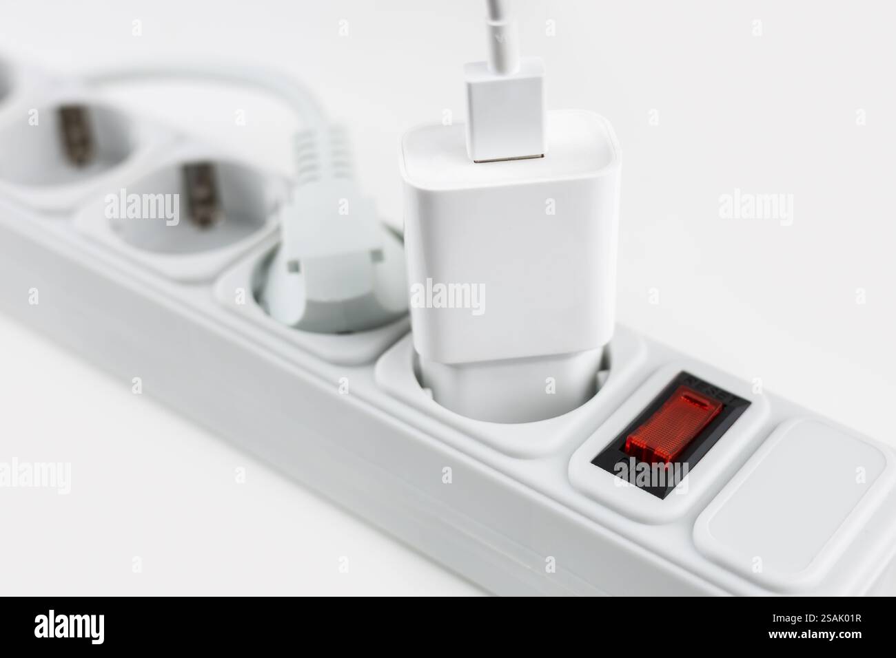 mobile phone chargers connected to electrical power strip. Various ...