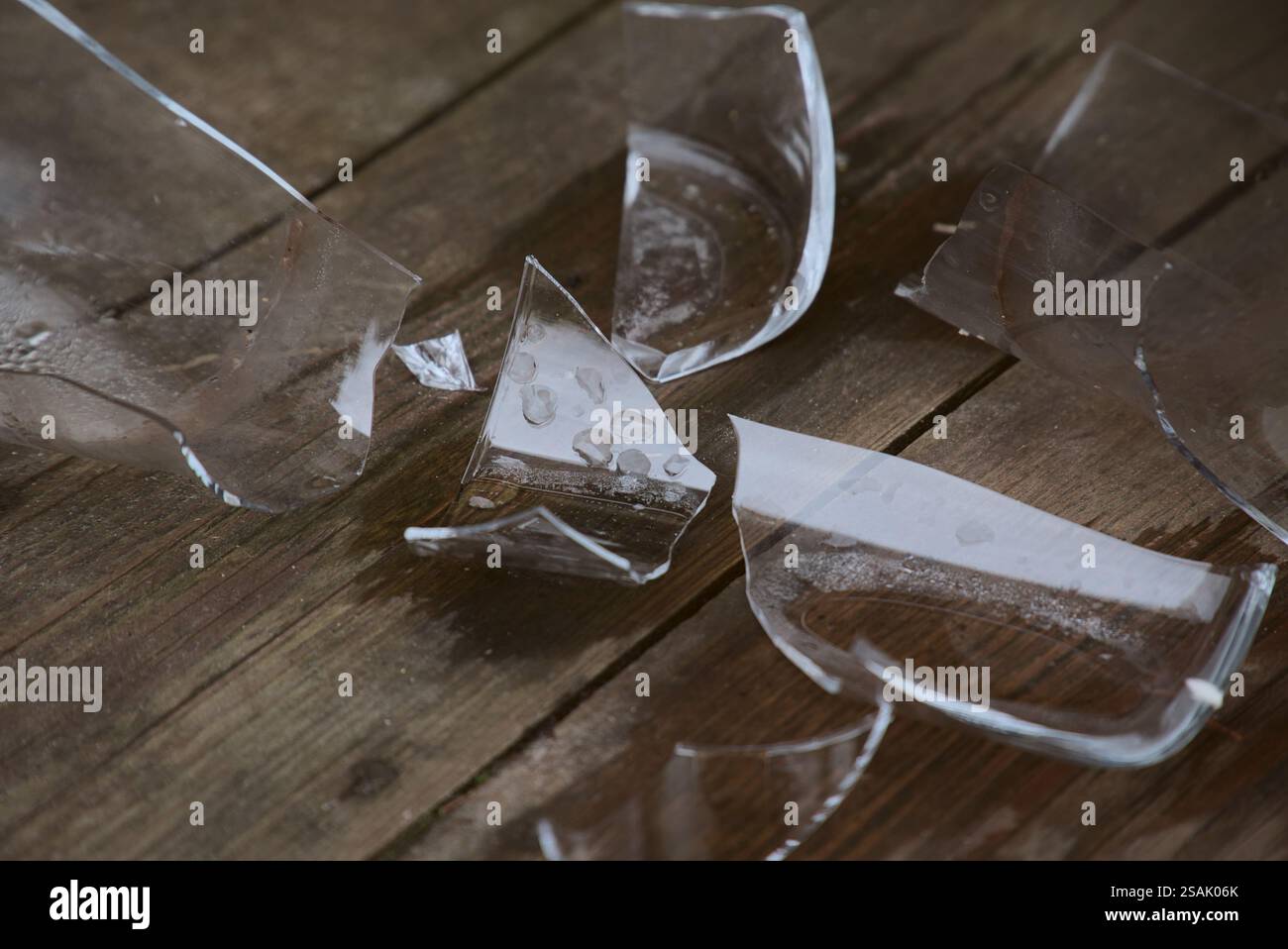 Pieces of a broken glass vessel on wooden floor Stock Photo - Alamy