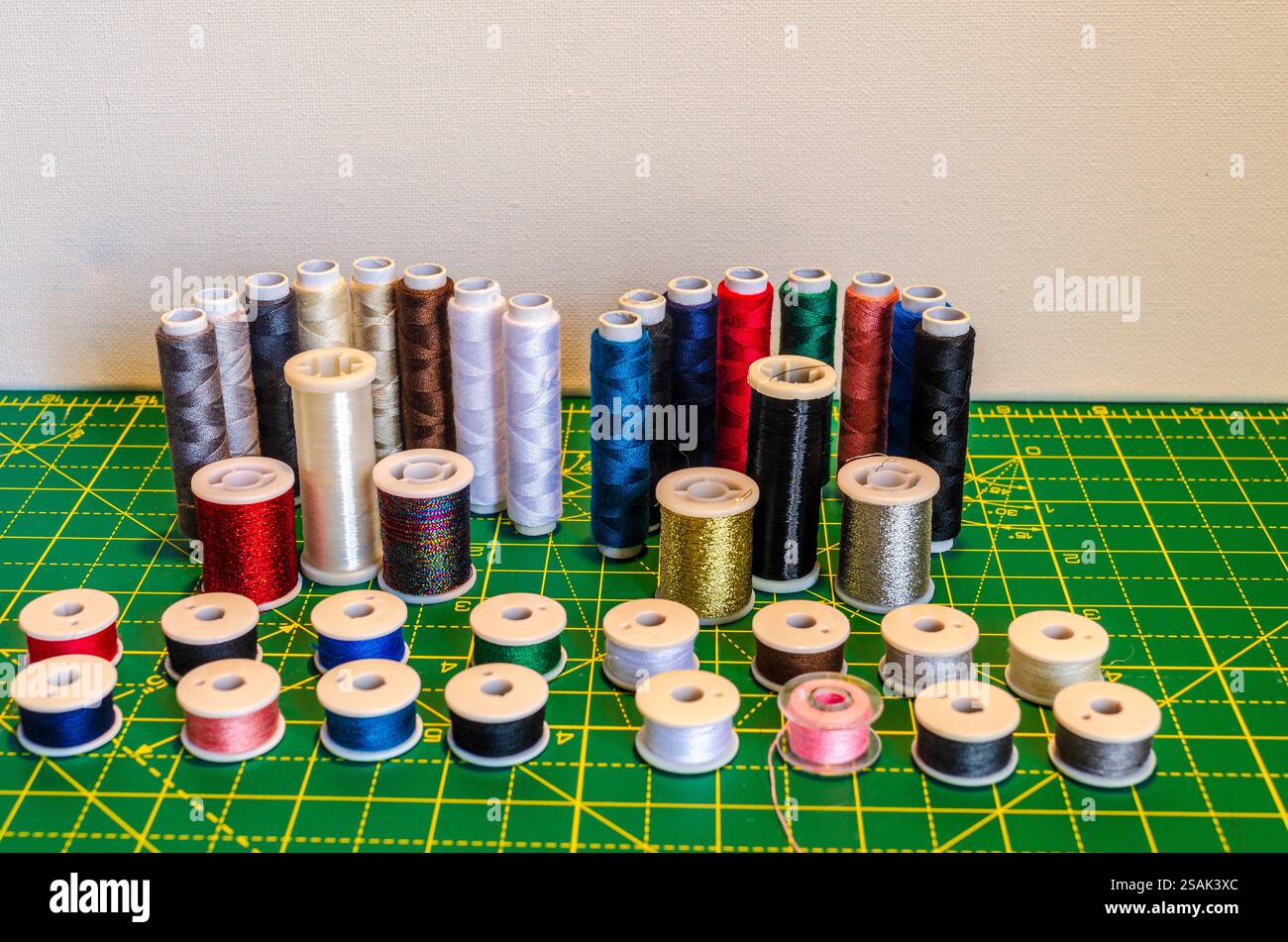 Collection of items used in a sewing kit on a cutting mat with white ...