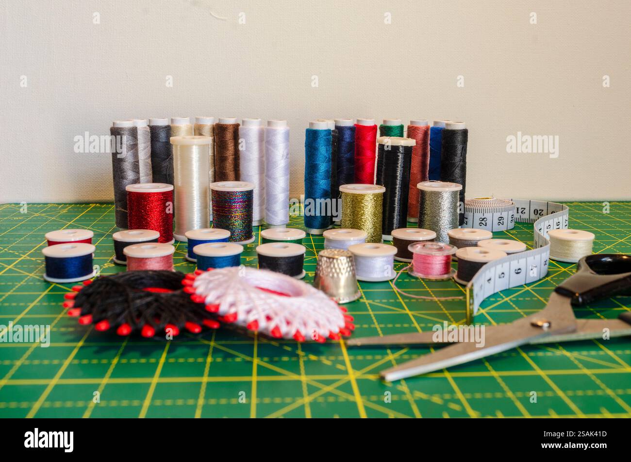 Collection of items used in a sewing kit on a cutting mat with white ...