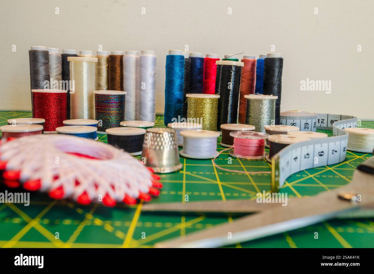 Collection of items used in a sewing kit on a cutting mat with white ...