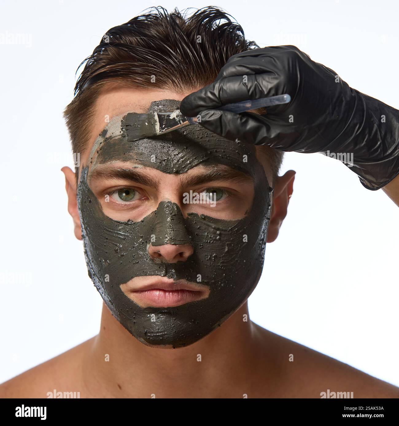 Man with smooth skin looking directly forward, and hand wearing black ...