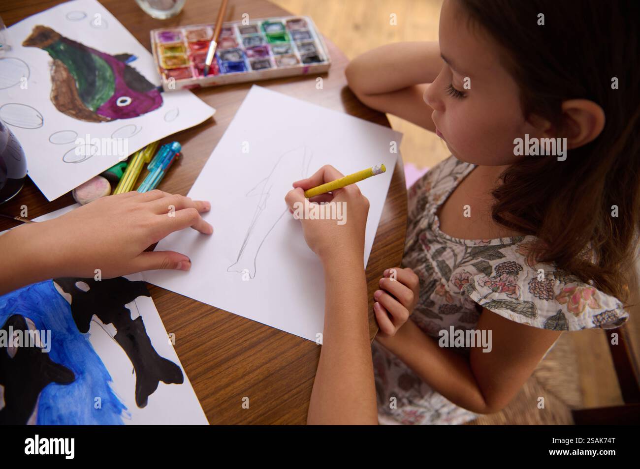 Child practicing artistic skills by drawing and painting fish ...