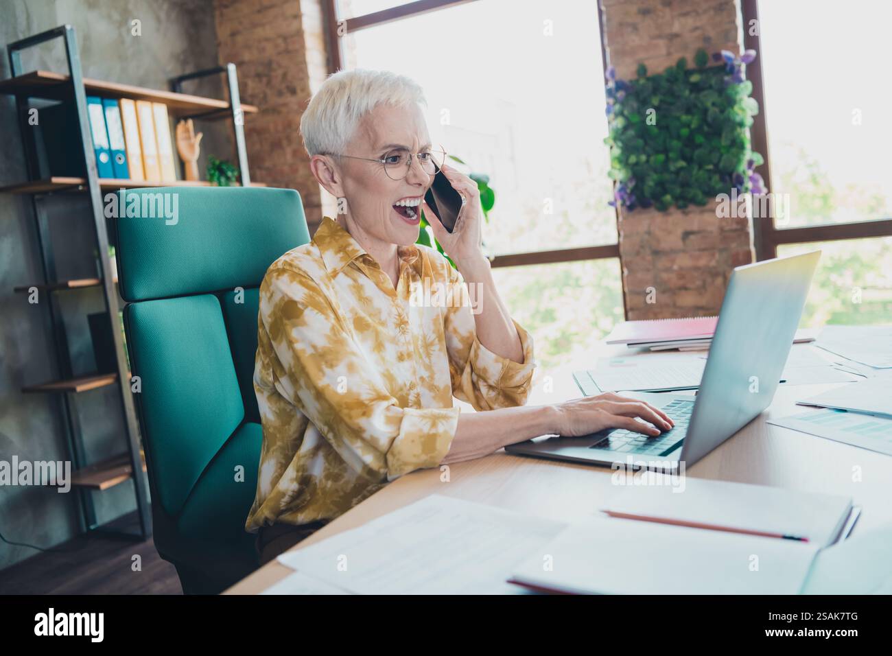 Photo of senior woman angry scream talk phone wear yellow print shirt ...