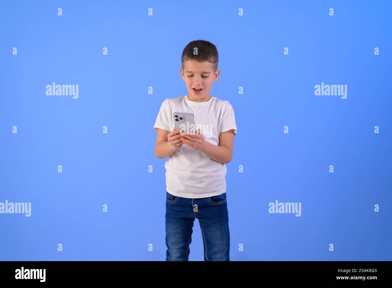 Portrait of cheerful adorable boy using social media apps over mobile ...
